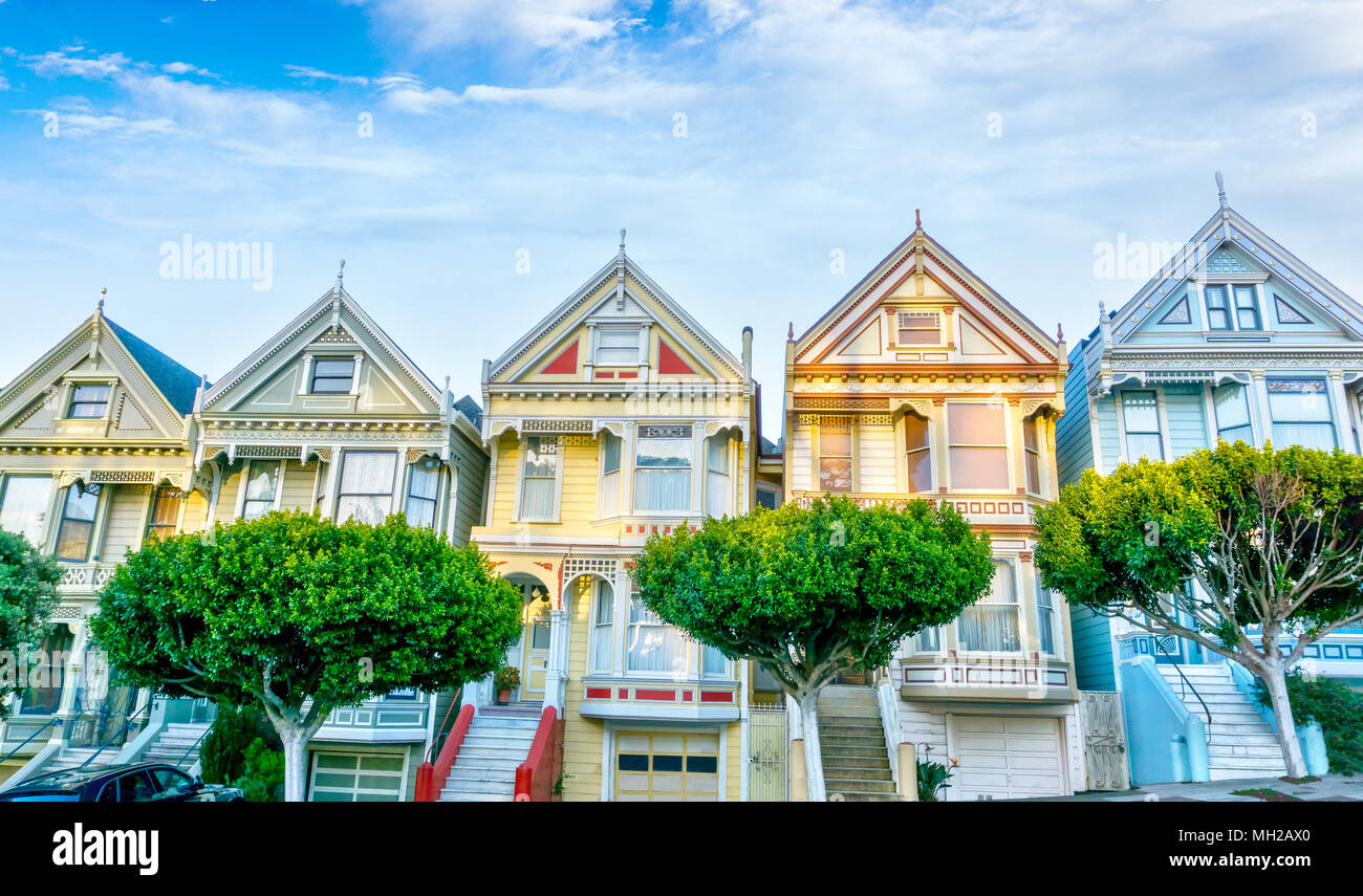 Late afternoon sun light up a row of colorful Victorian houses known as ...