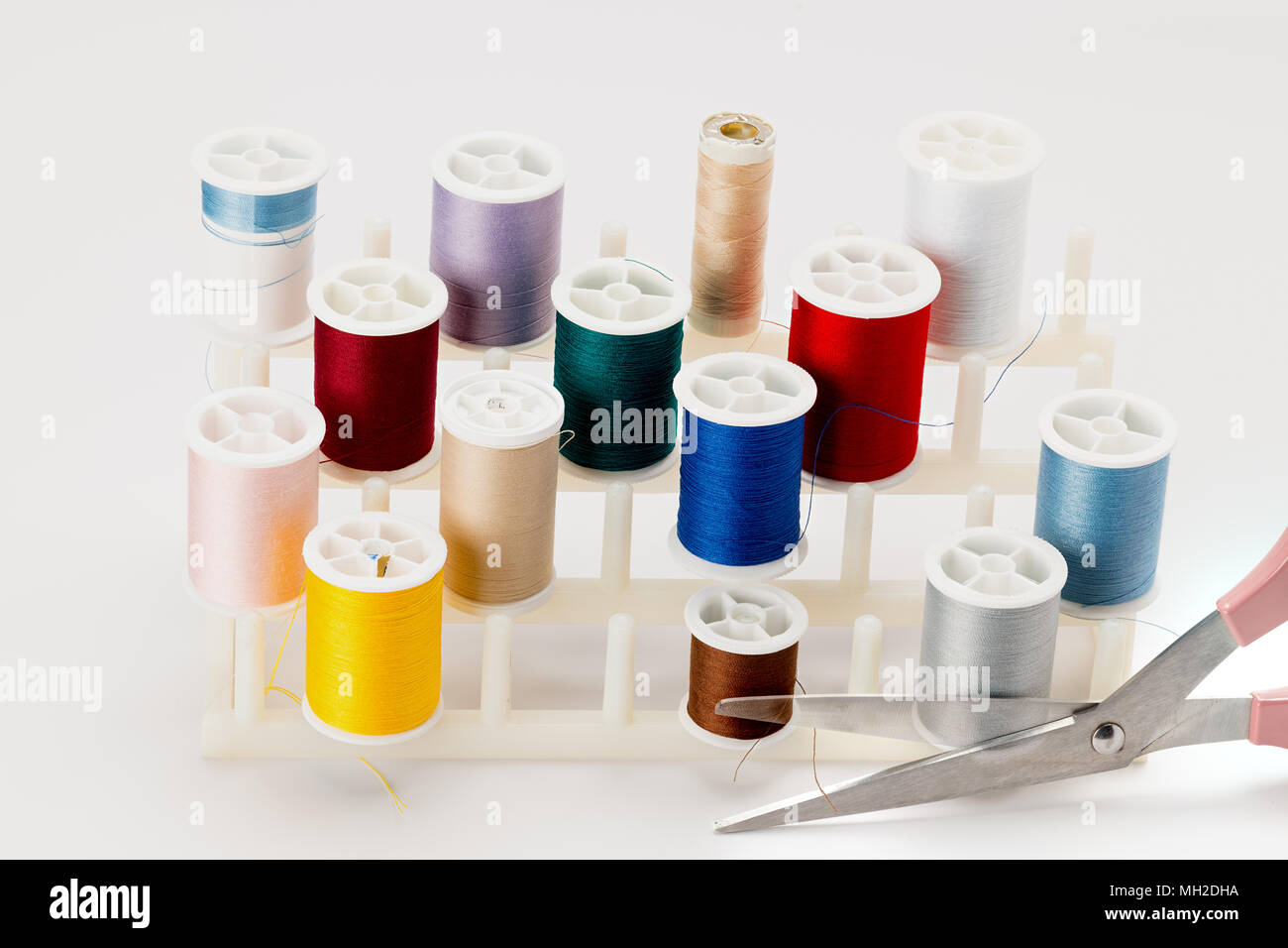 Round spools of thread used for sewing clothes mounted in a holder ...