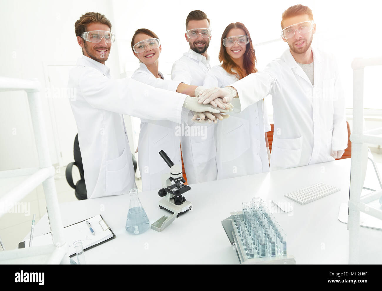 successful team of young scientists with hands clasped together.the ...