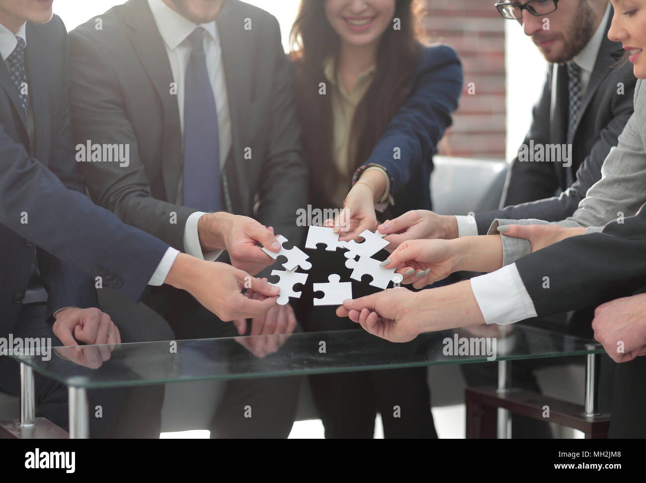 Business team solving puzzle together Stock Photo - Alamy