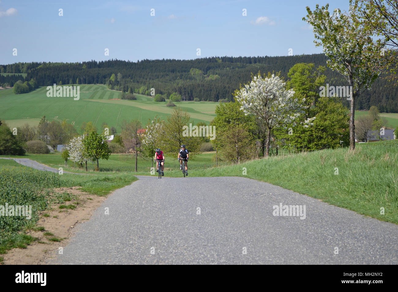 Spring bike riding on the beautiful hills, Young couple on bikes riding ...