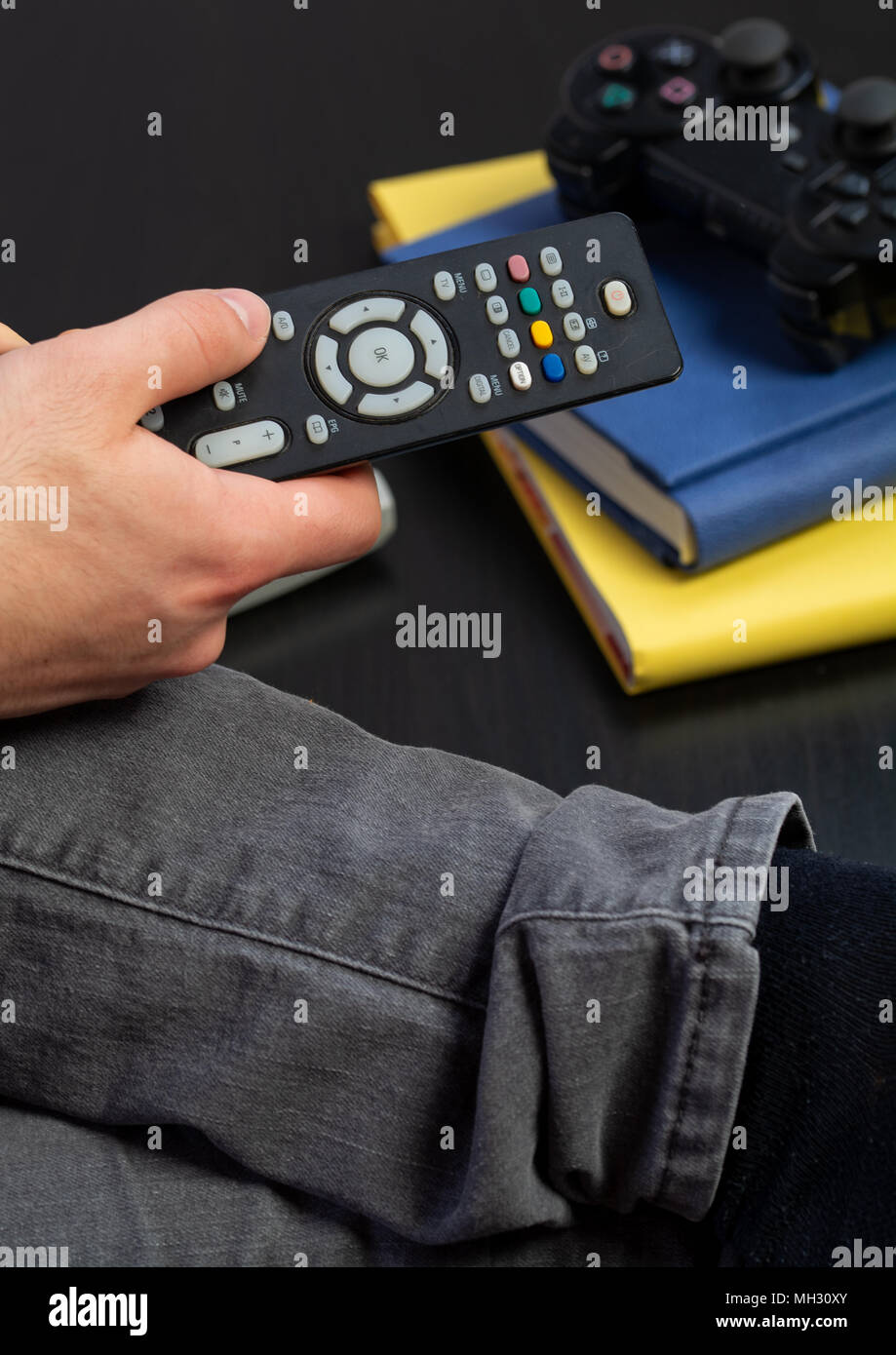 a young man with black changing the channel of the tv, relaxing Stock ...