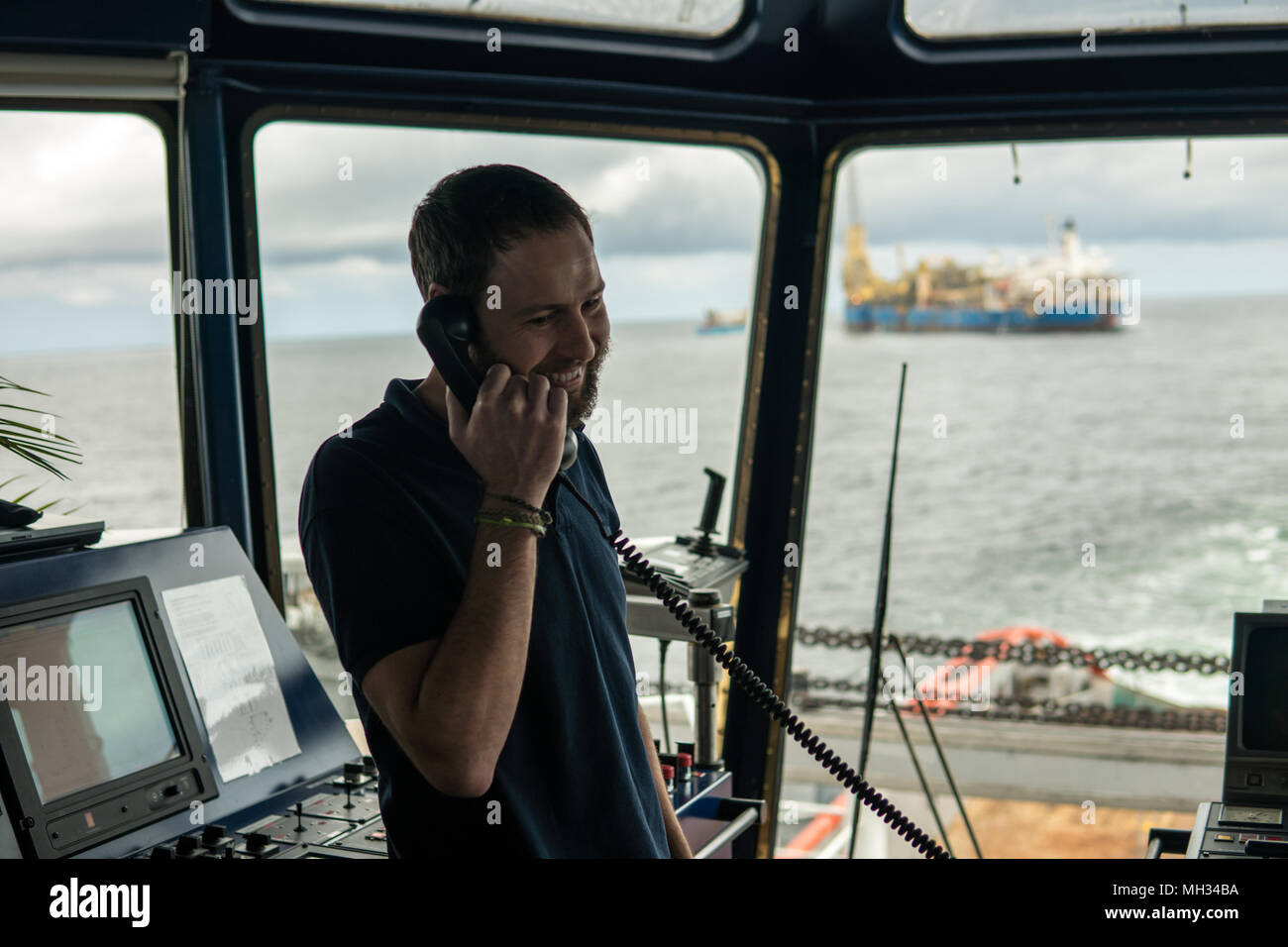 Deck navigation officer on the navigation bridge. He looks through ...