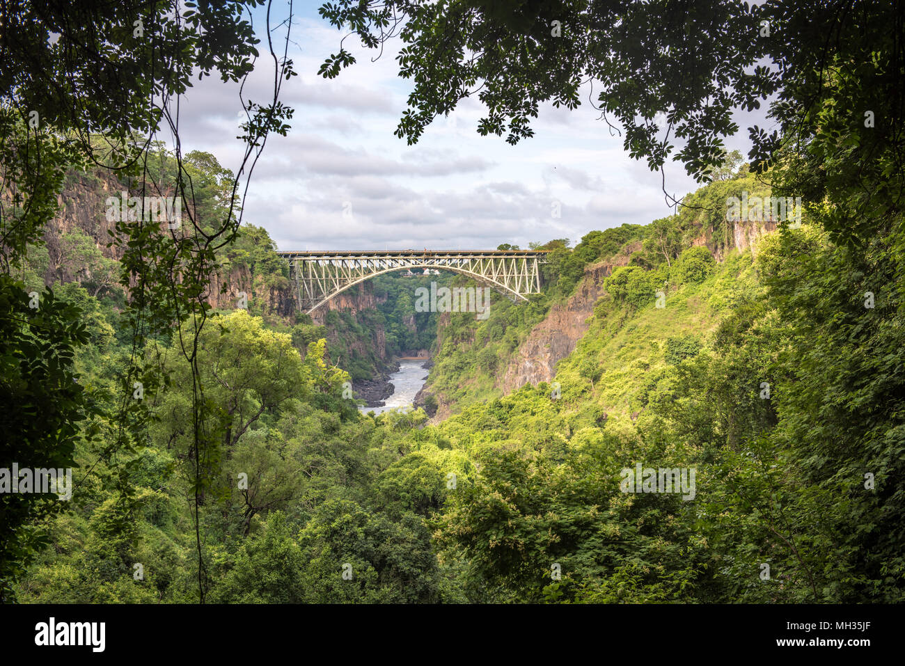 The Victoria Falls Bridge crosses the Zambezi River surrounded by thick ...