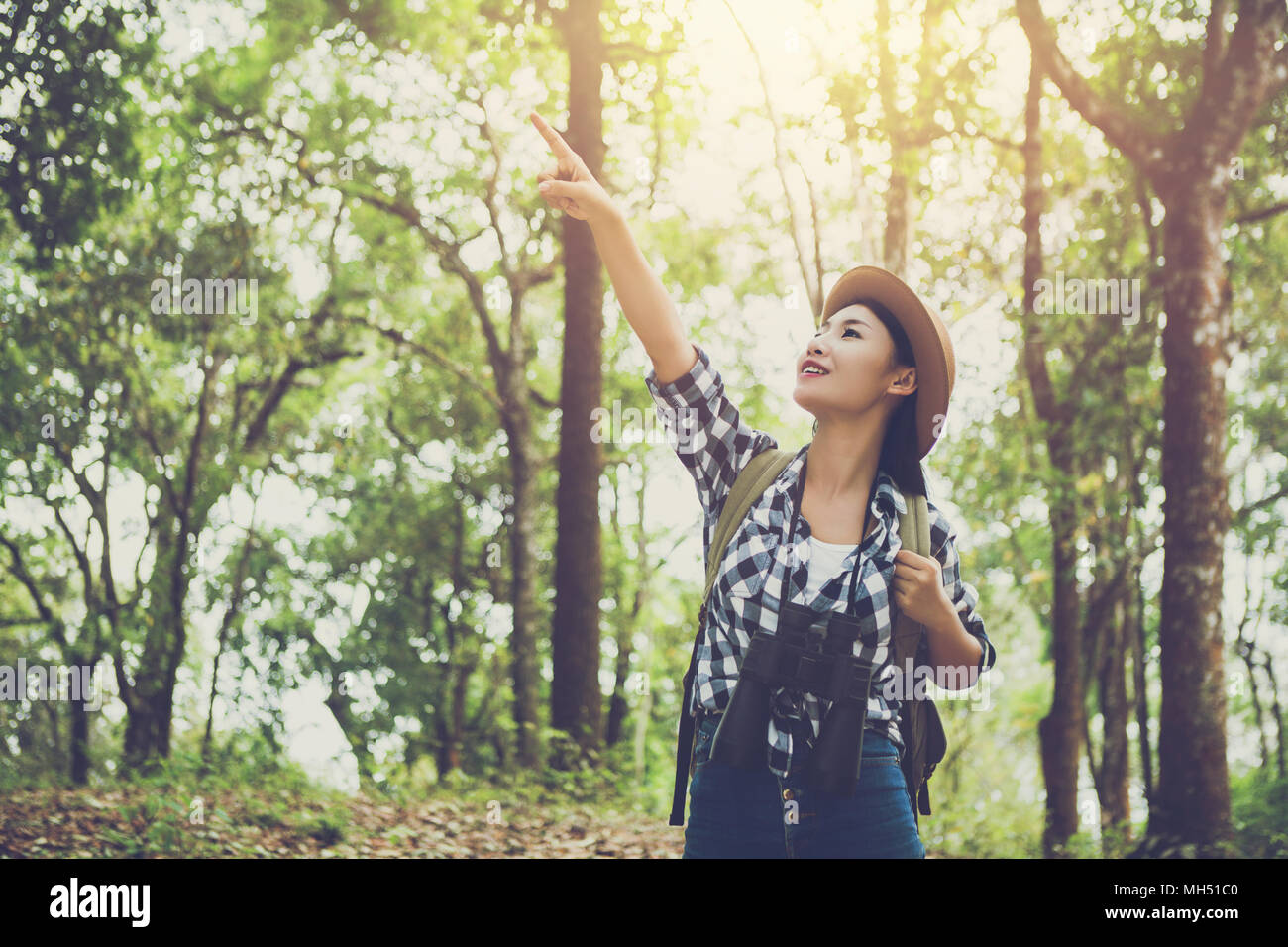 Young woman hiker with backpack watching trekking map, Hiking concept ...