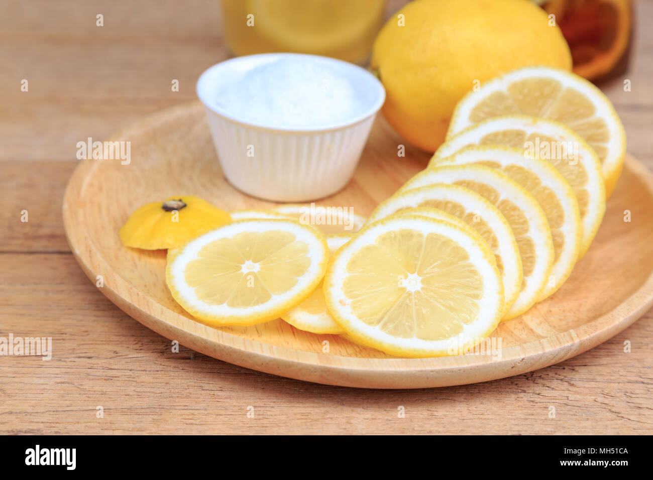 Lemon slice and salt on wood plate and wooden table with copy space ...
