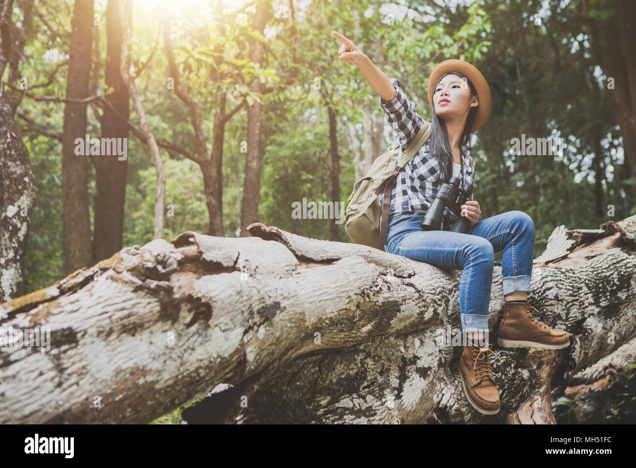 Young woman hiker with backpack watching trekking map, Hiking concept ...