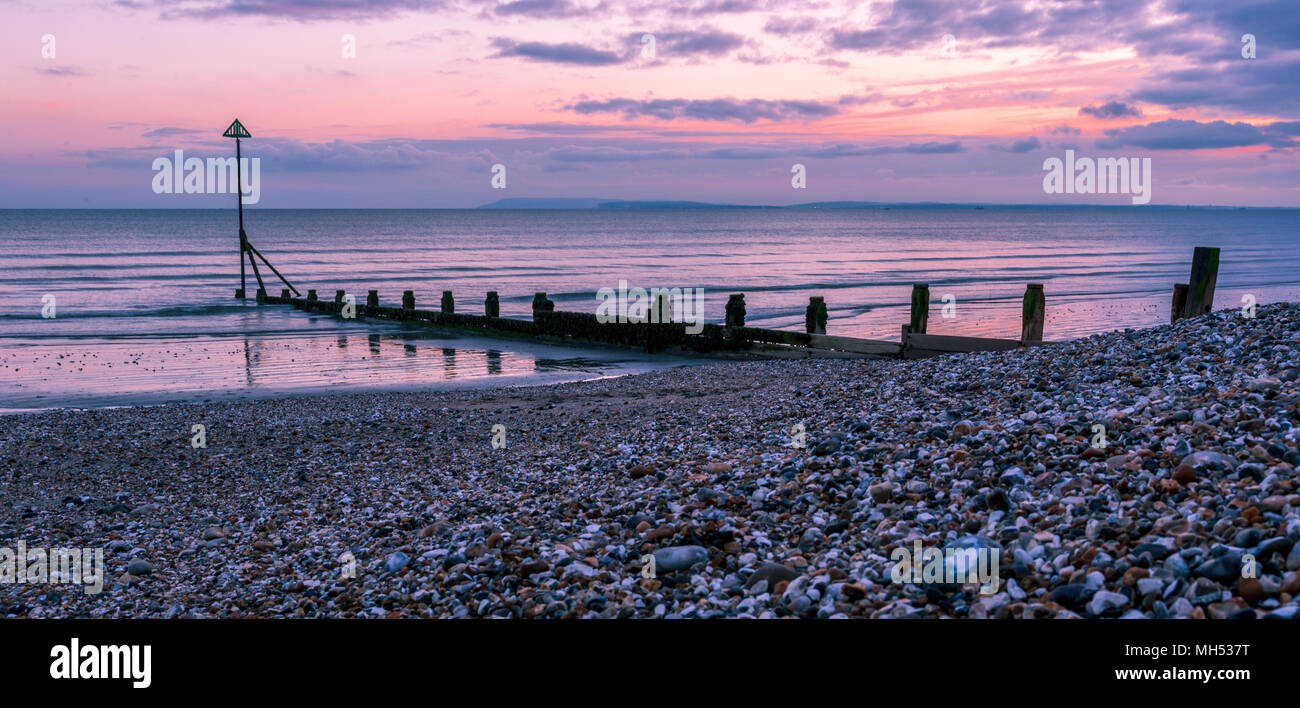 Sunset, groynes and silhouettes on the East Wittering shoreline ...