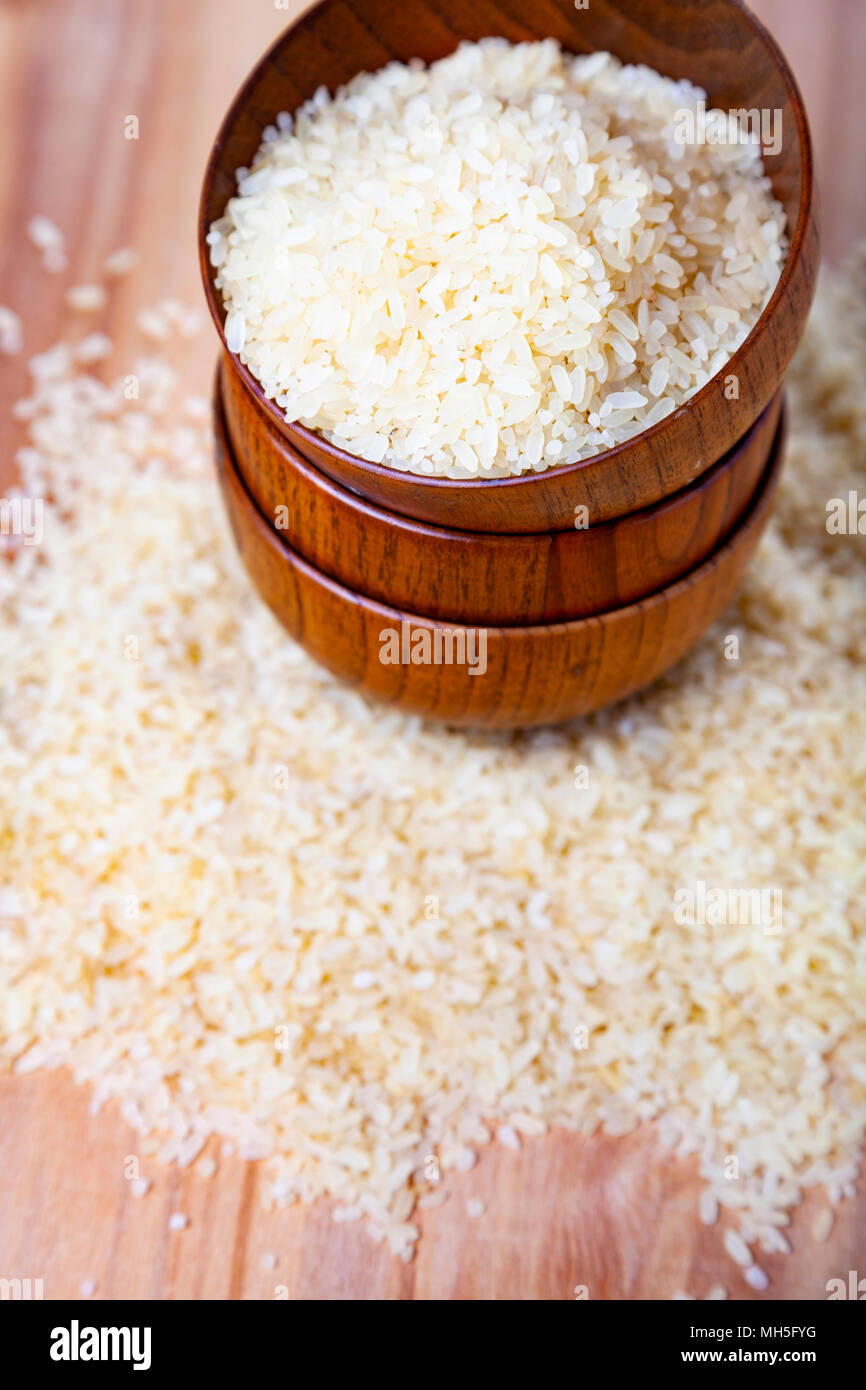 Raw steamed rice in a bowl on a wooden background. Ingredient for a ...