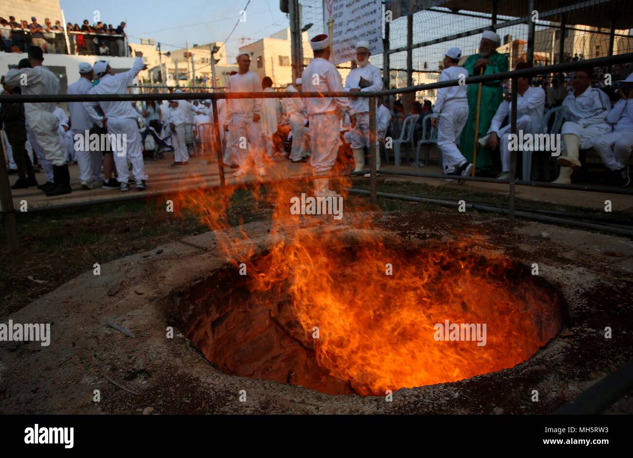 Fire burns inside a sunken fire pit, where Passover Lambs are cooked as ...