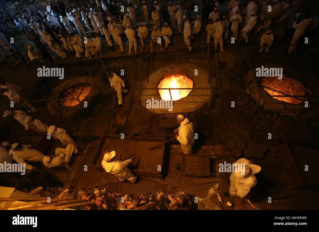 Members of the Samaritan community prepare blazing fire pits to cook ...