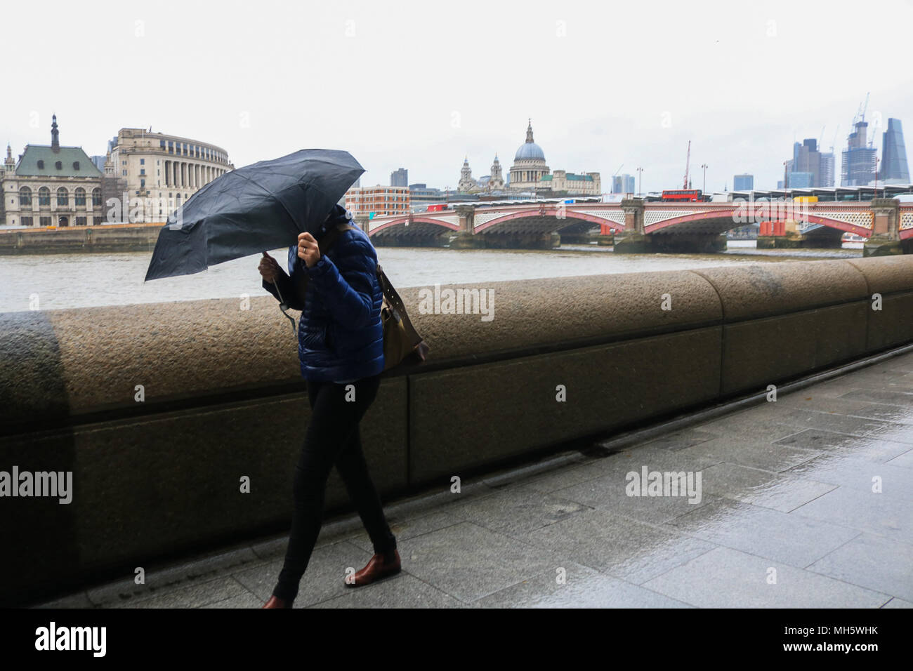 London UK. 30th April 2018. Pedestrians brave the freezing cold lashing ...
