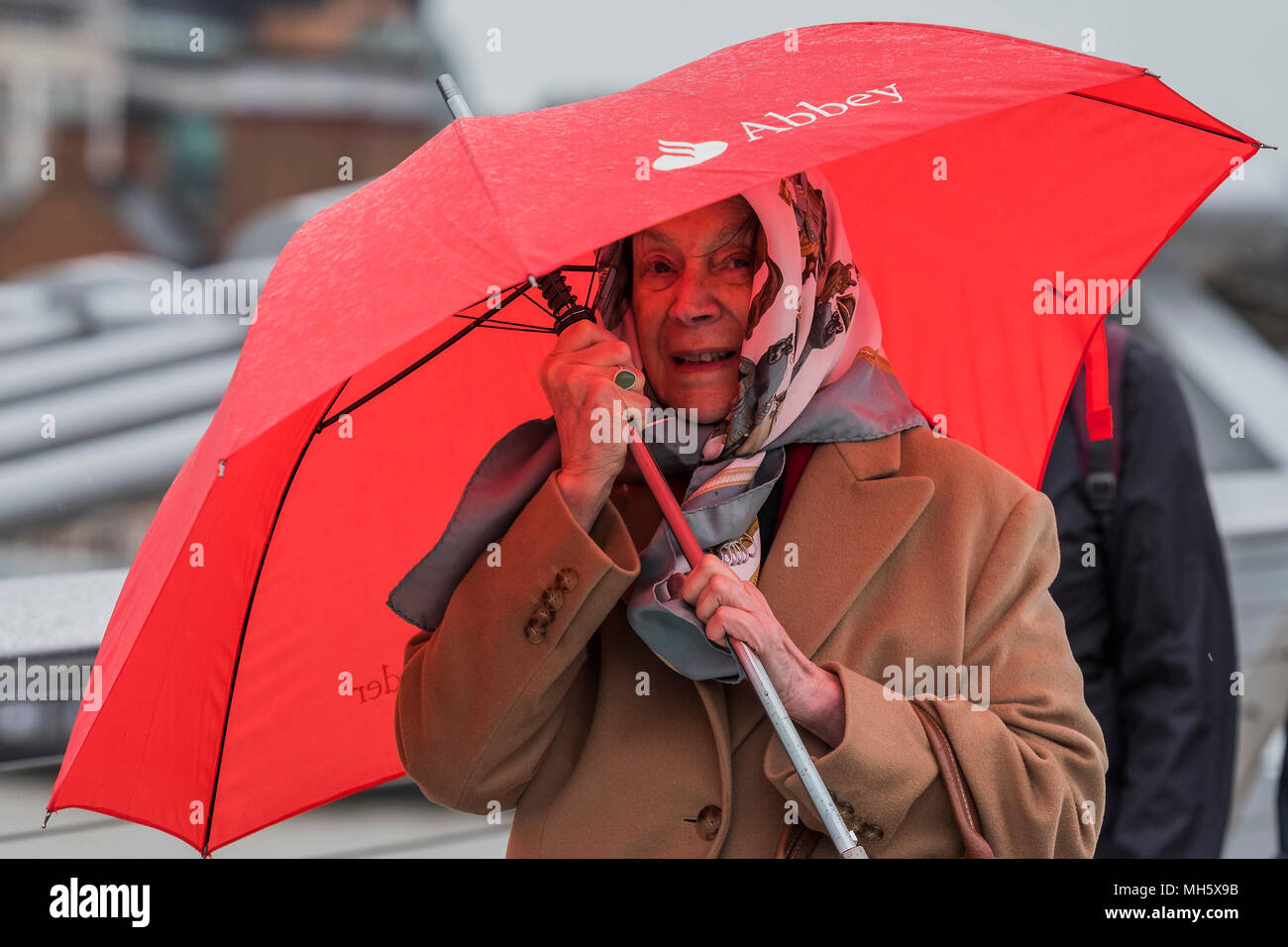 London, UK. 30th April 2018. An old lady makes her way slowly accross ...