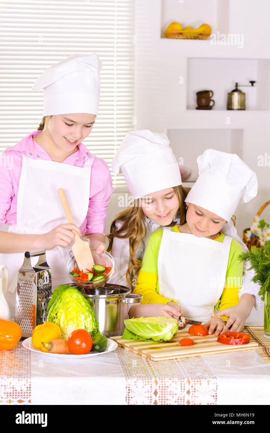 happy cute girls cooking vegetable dish Stock Photo - Alamy