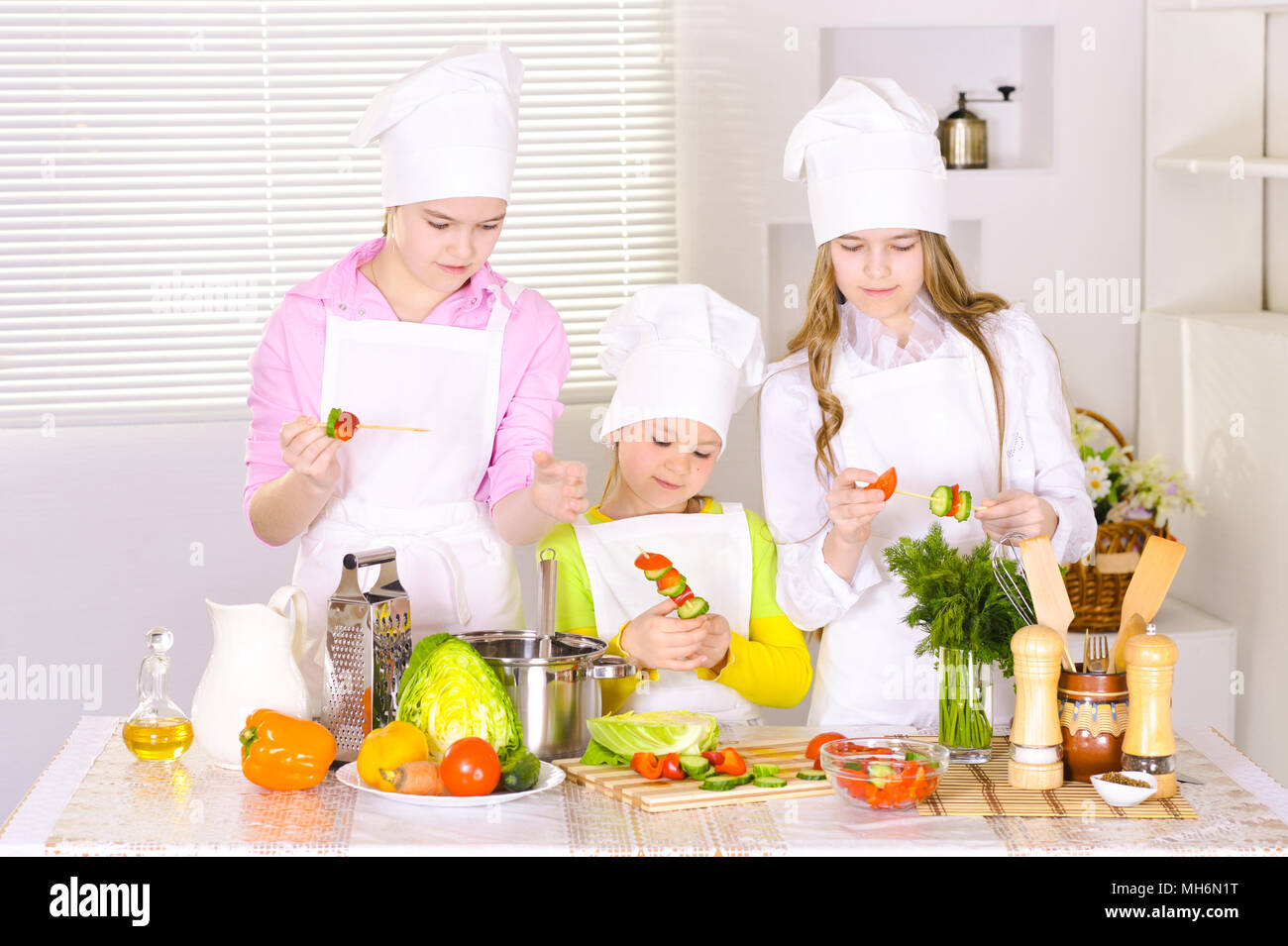 happy cute girls cooking vegetable dish Stock Photo - Alamy