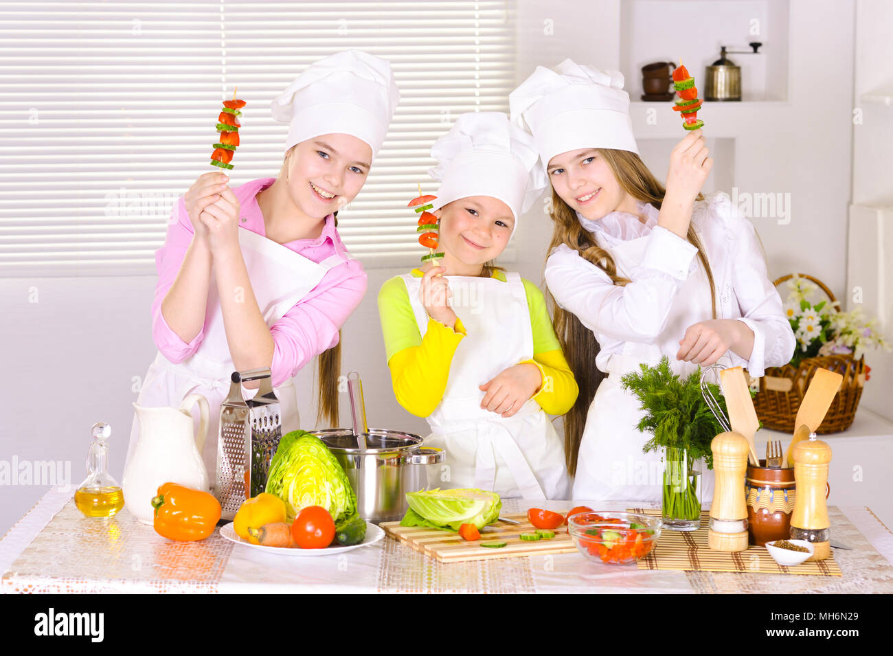 happy cute girls cooking vegetable dish Stock Photo - Alamy