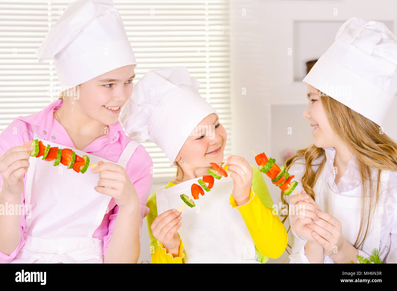 happy cute girls cooking vegetable dish Stock Photo - Alamy
