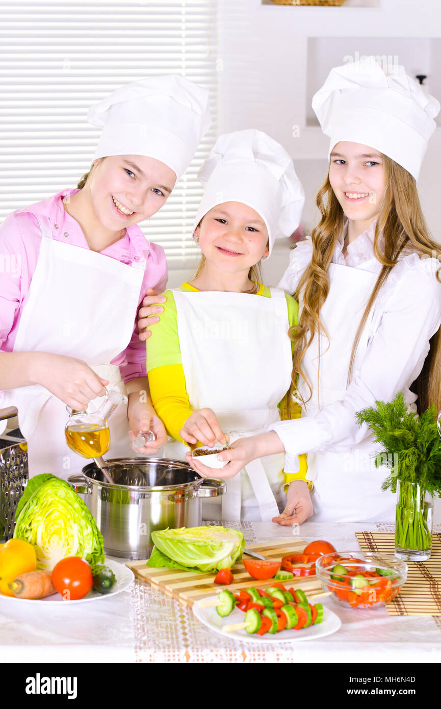 happy cute girls cooking vegetable dish Stock Photo - Alamy