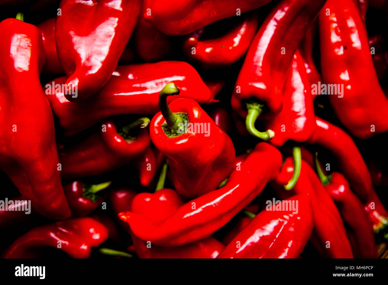 Piles of fresh red peppers for sale at a market stall during the night ...