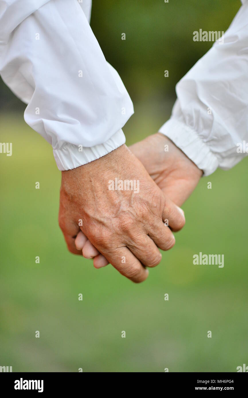 Elderly couple holding hands Stock Photo - Alamy