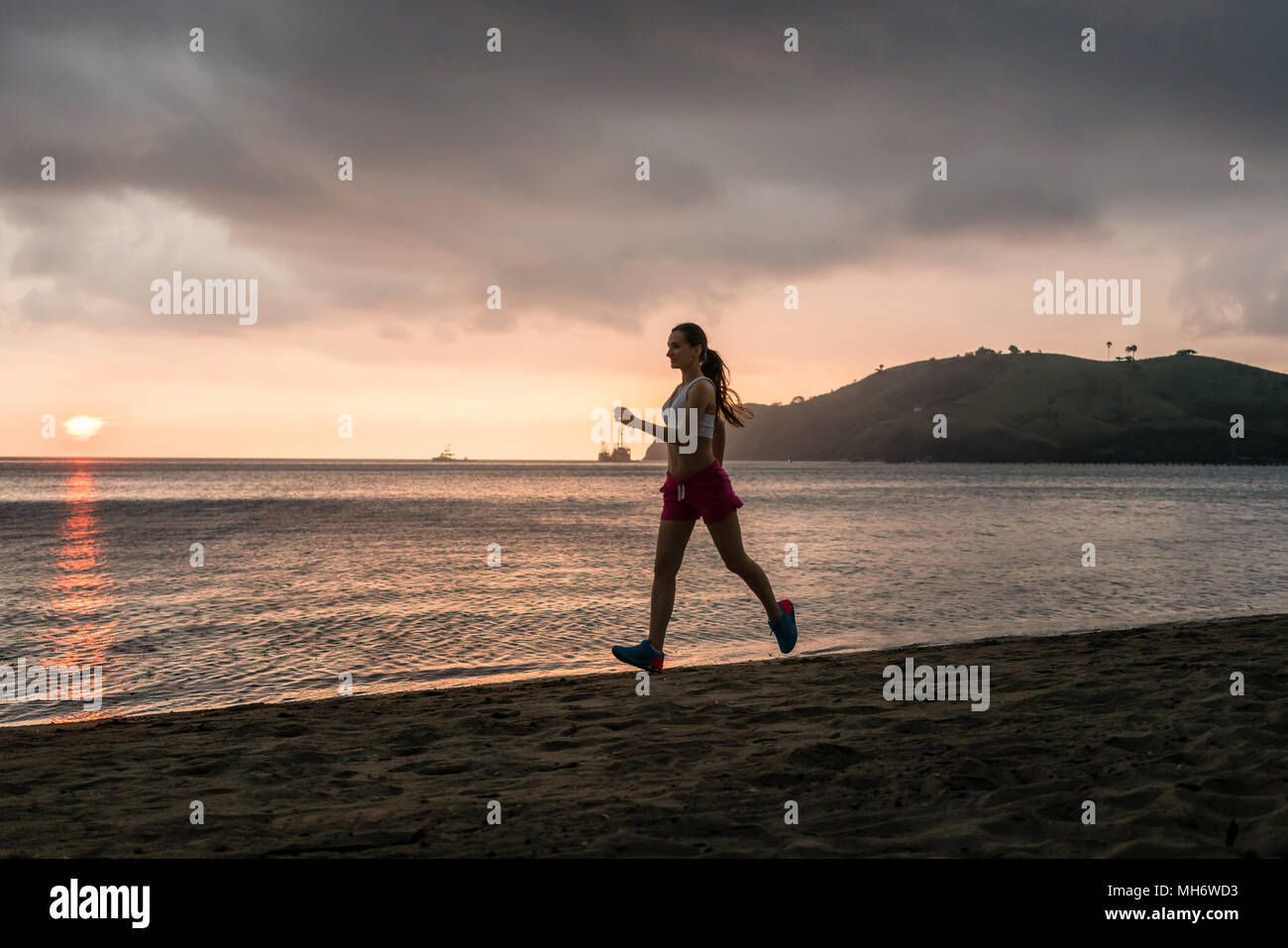 Fit young woman running on the beach during summer vacation in Flores ...