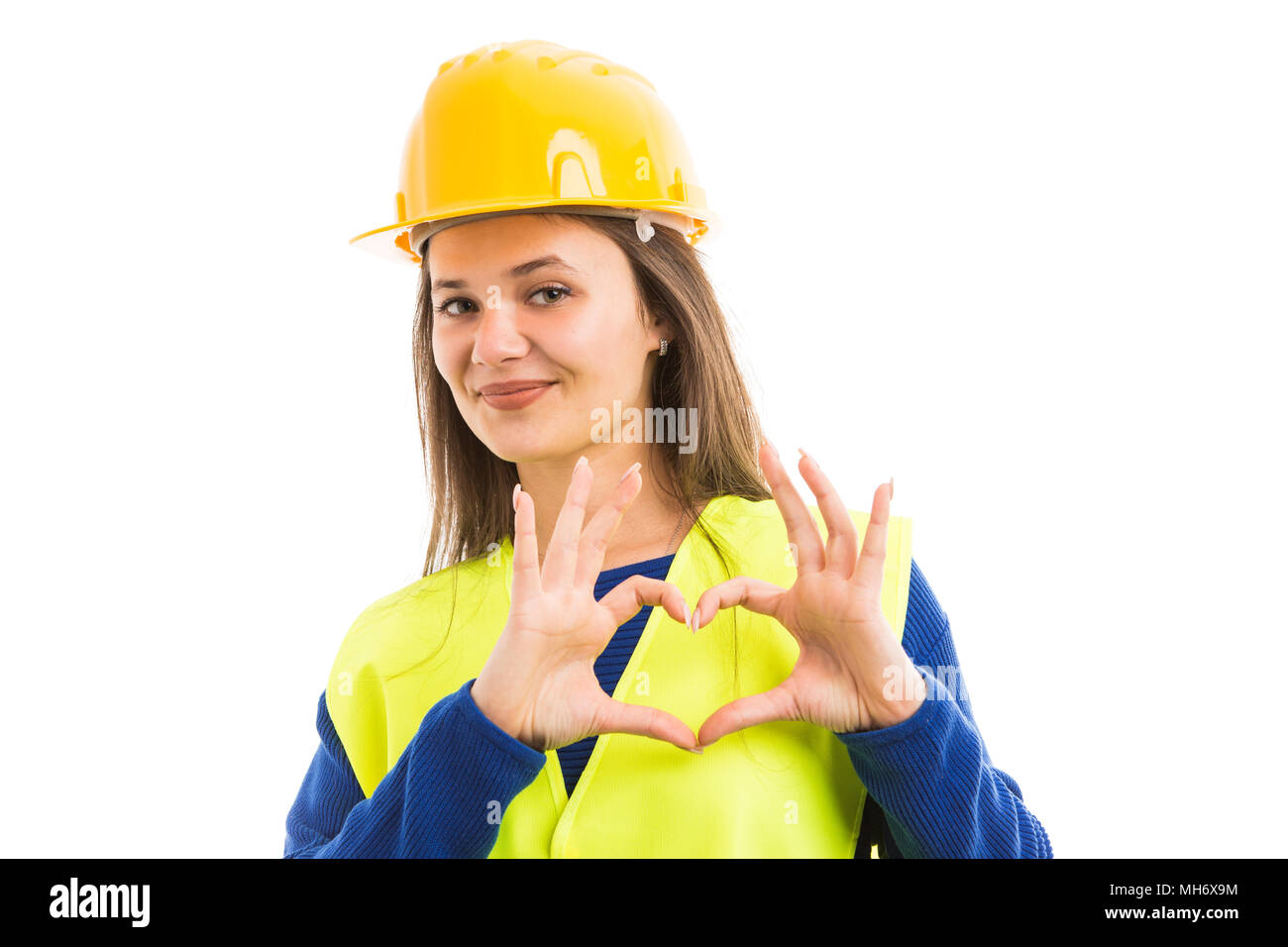Young female constructor or engineer showing heart sign with hands as ...