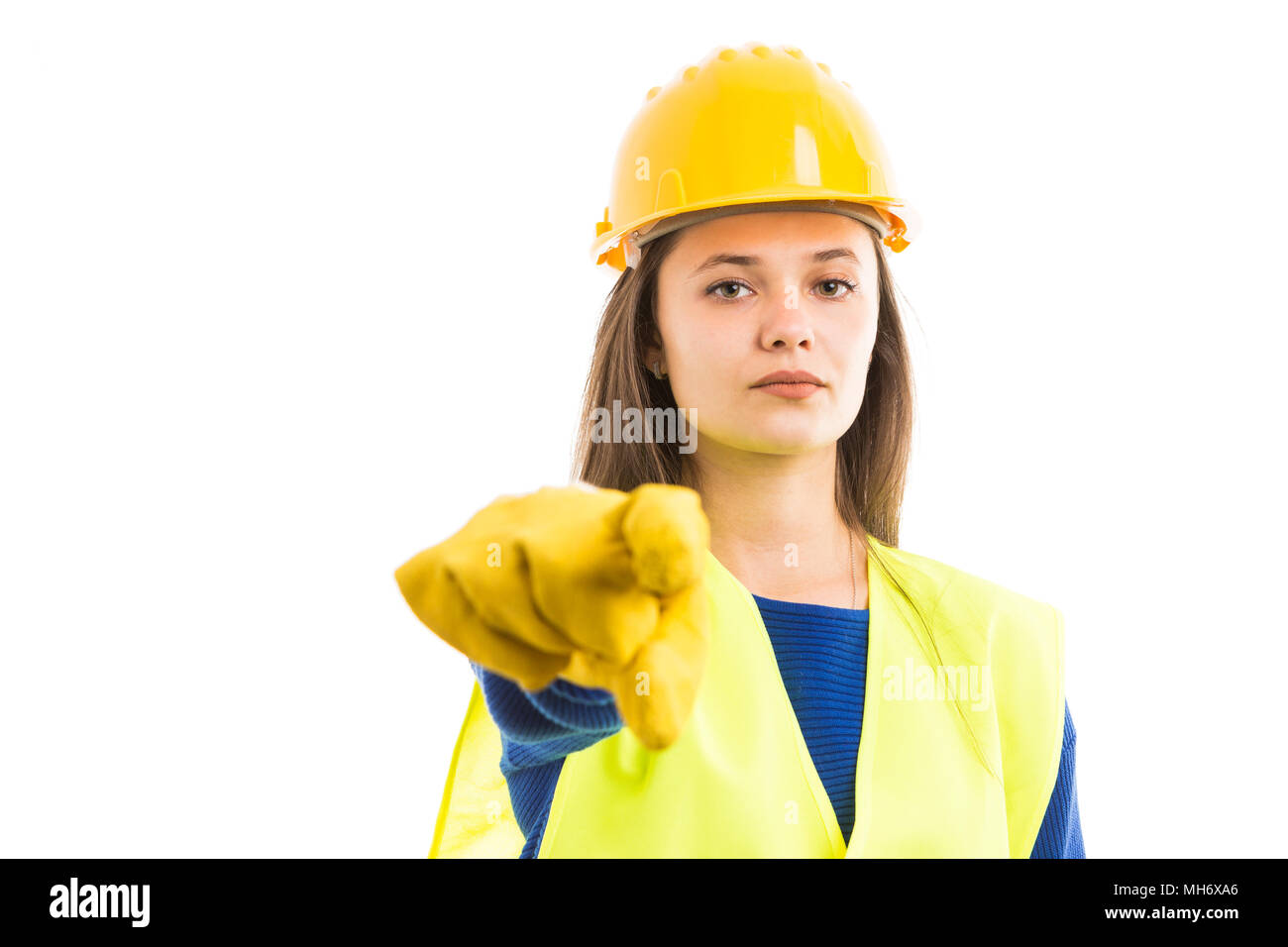 Young serious female constructor or engineer pointing forward as ...