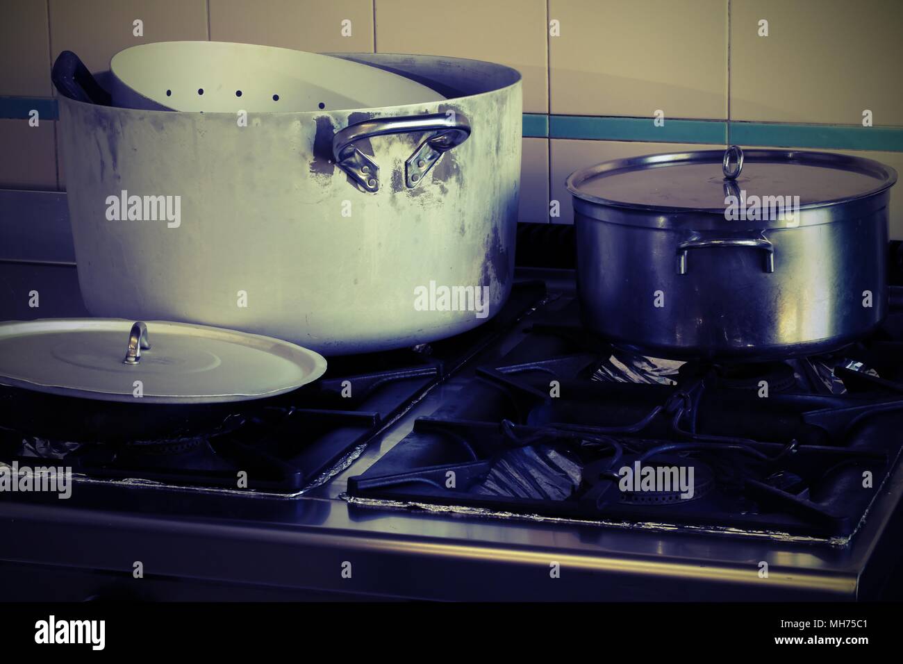 many pots on the stove in the industrial kitchen with vintage effect ...