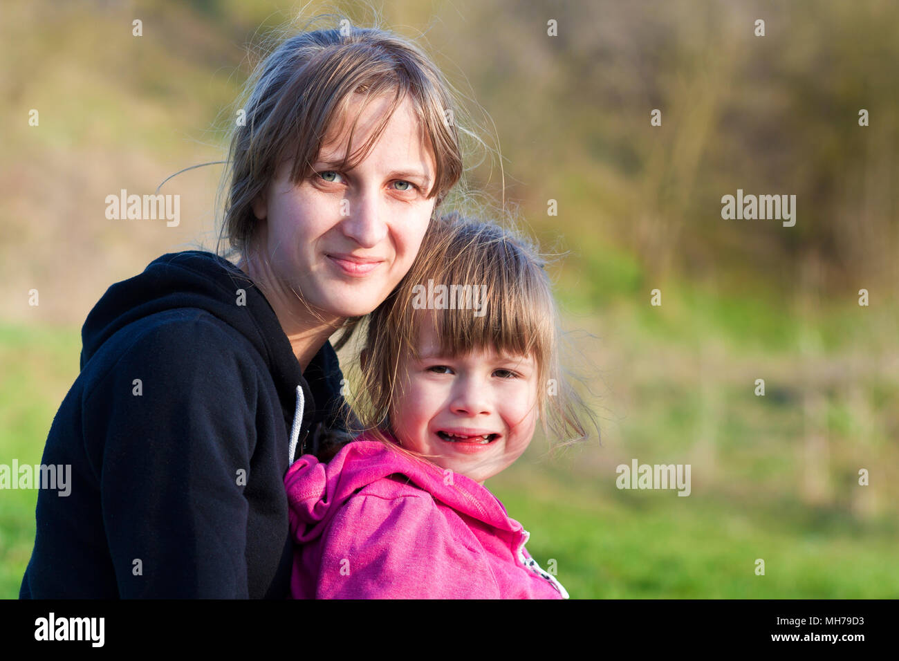 Portrait of young beautiful blond motherl hugging lovingly and ...