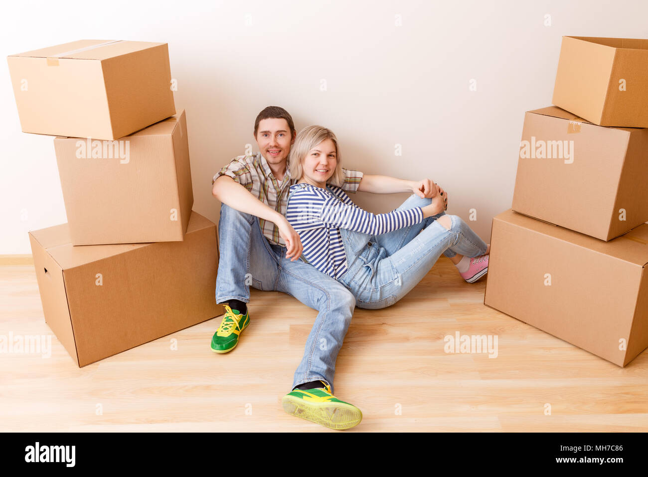 Image of man and woman sitting on floor among cardboard boxes Stock ...