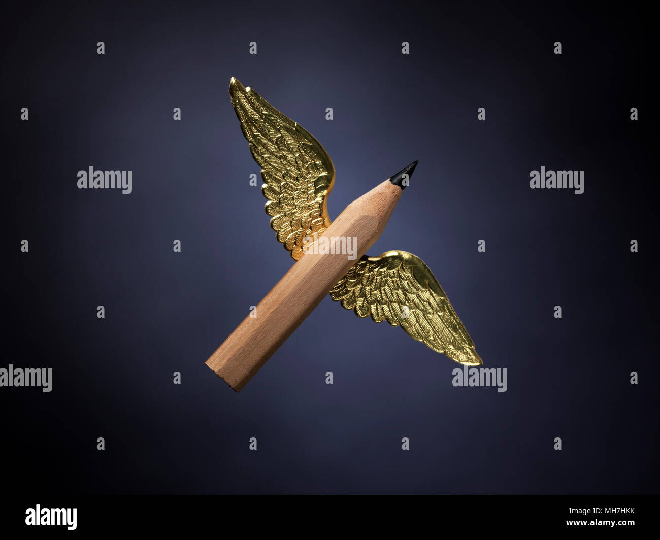 Pencil with golden wings flying across dark blue background Stock Photo ...