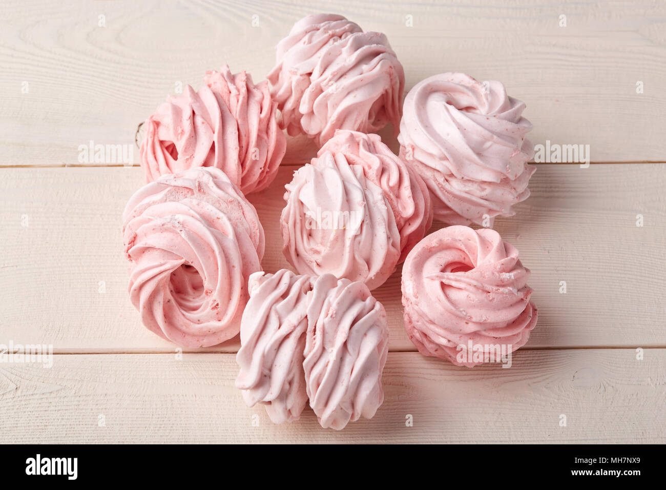 Pink sweet homemade airy zephyr or marshmallows on white wooden ...