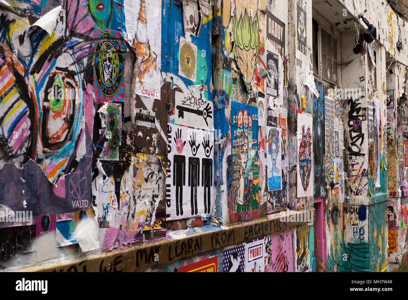 wall covered in flyposters off Brick Lane in Whitechapel East London ...