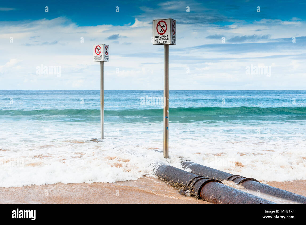 Warning signs and a pipe on a beach in Sydney Australia Stock Photo - Alamy