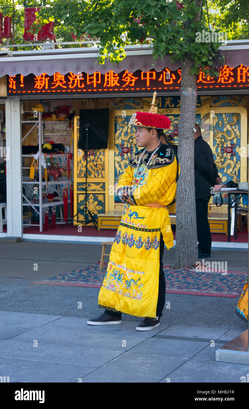 Chinese man in traditional dress advertising a restaurant in Olympic ...