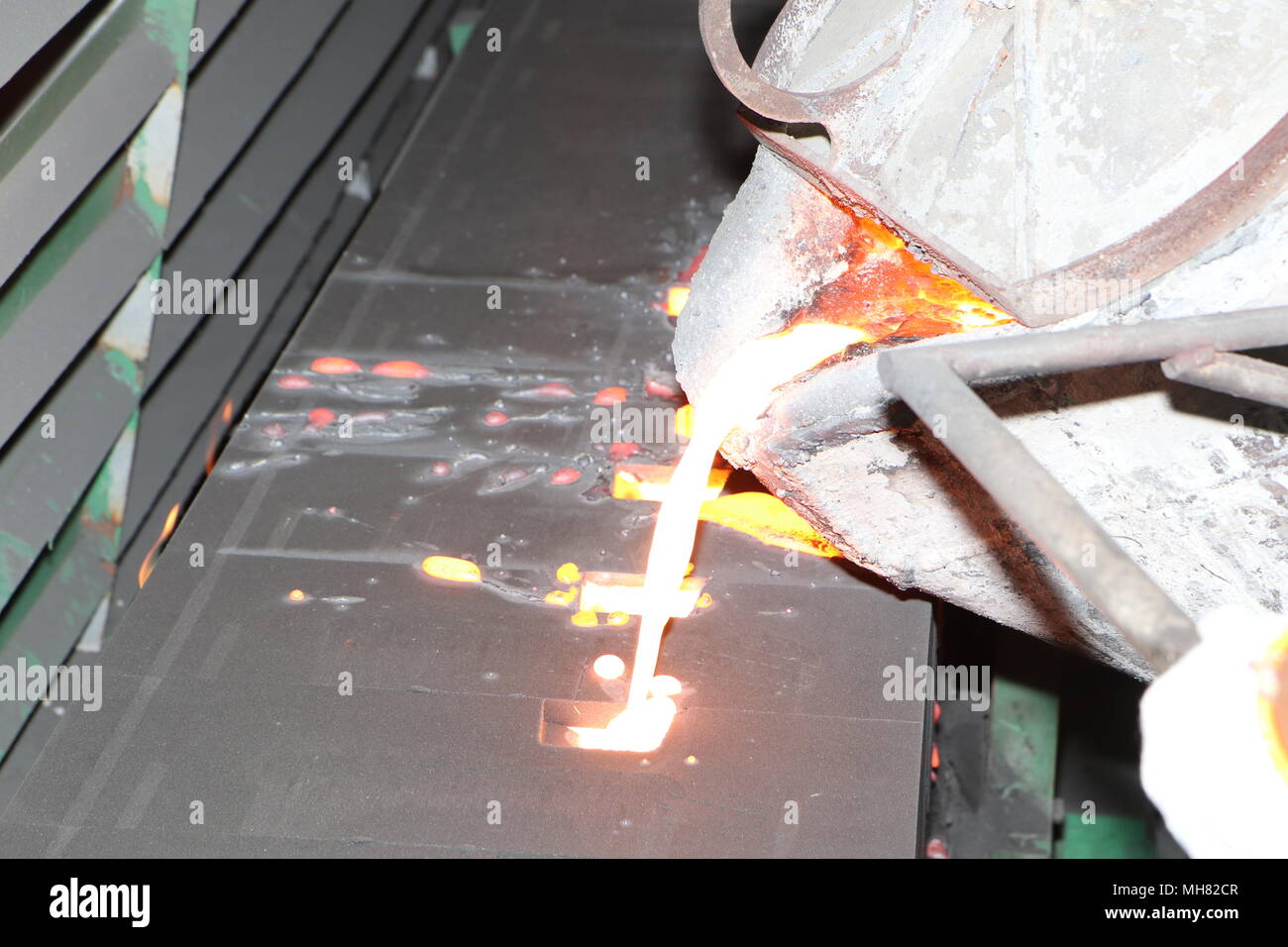 Iron molten metal pouring in sand mold ; green sand process Stock Photo ...