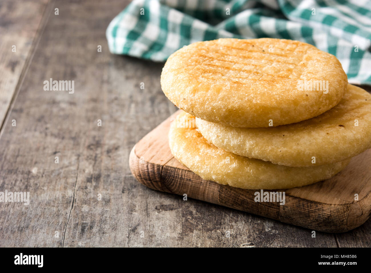 Arepas on wooden table. Venezuelan typical food Stock Photo - Alamy
