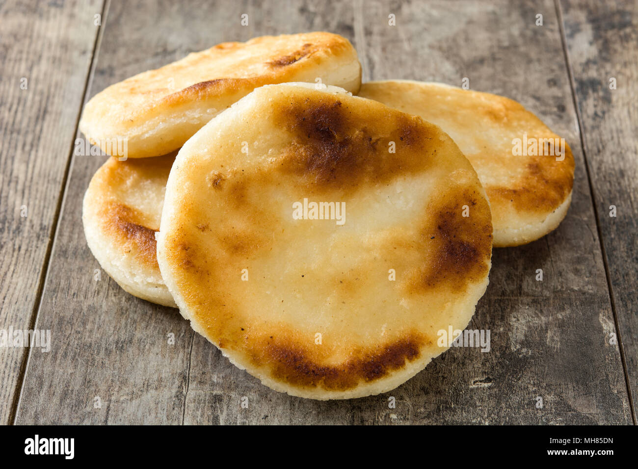 Arepas on wooden table. Venezuelan typical food Stock Photo - Alamy