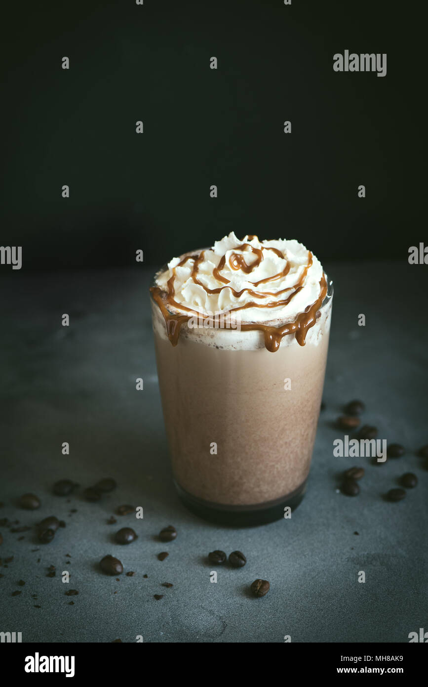 Cold Frappe Coffee (frappuccino) with whipped cream and caramel on dark ...