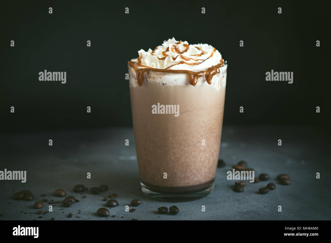 Cold Frappe Coffee (frappuccino) with whipped cream and caramel on dark ...