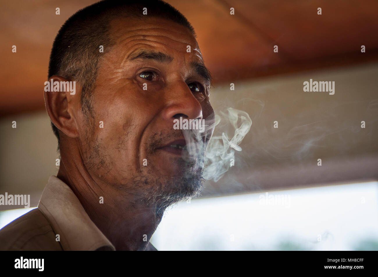 Yangshuo, China - August 2, 2012: Portrait of a Chinese man smoking a ...
