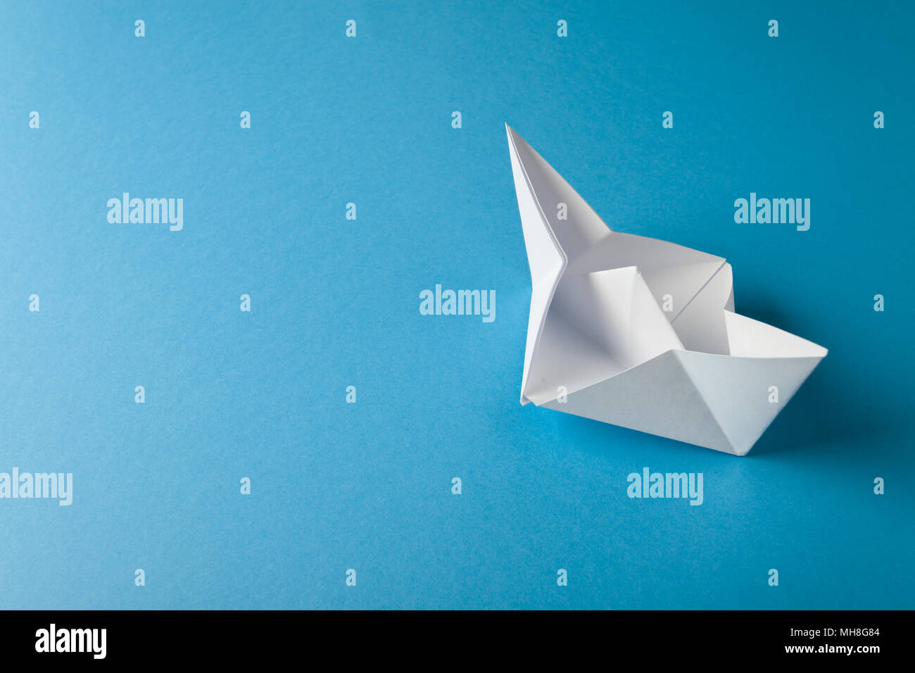 boat paper origami on the blue background. studio shot Stock Photo - Alamy