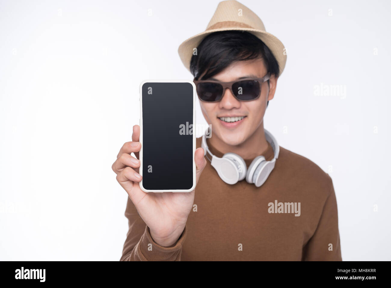 Smart casual asian man seated on chair, showing smartphone screen in ...
