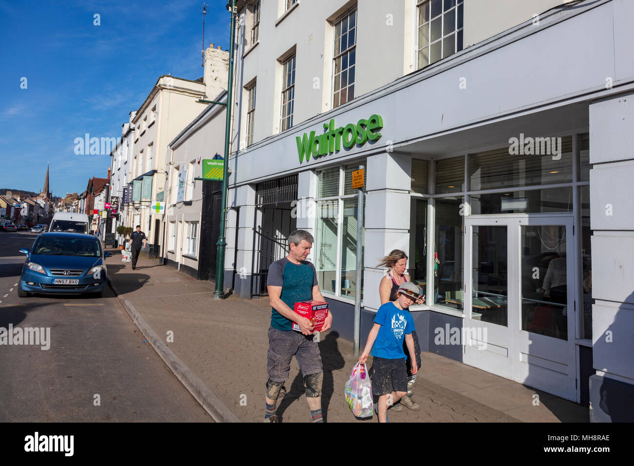 A young family carry their shopping from Waitrose on Monnow Street ...