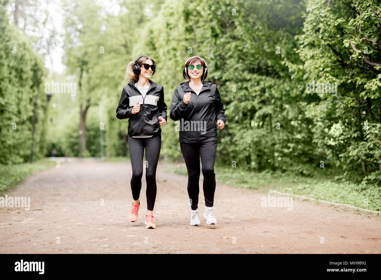 Two women running in the park Stock Photo - Alamy