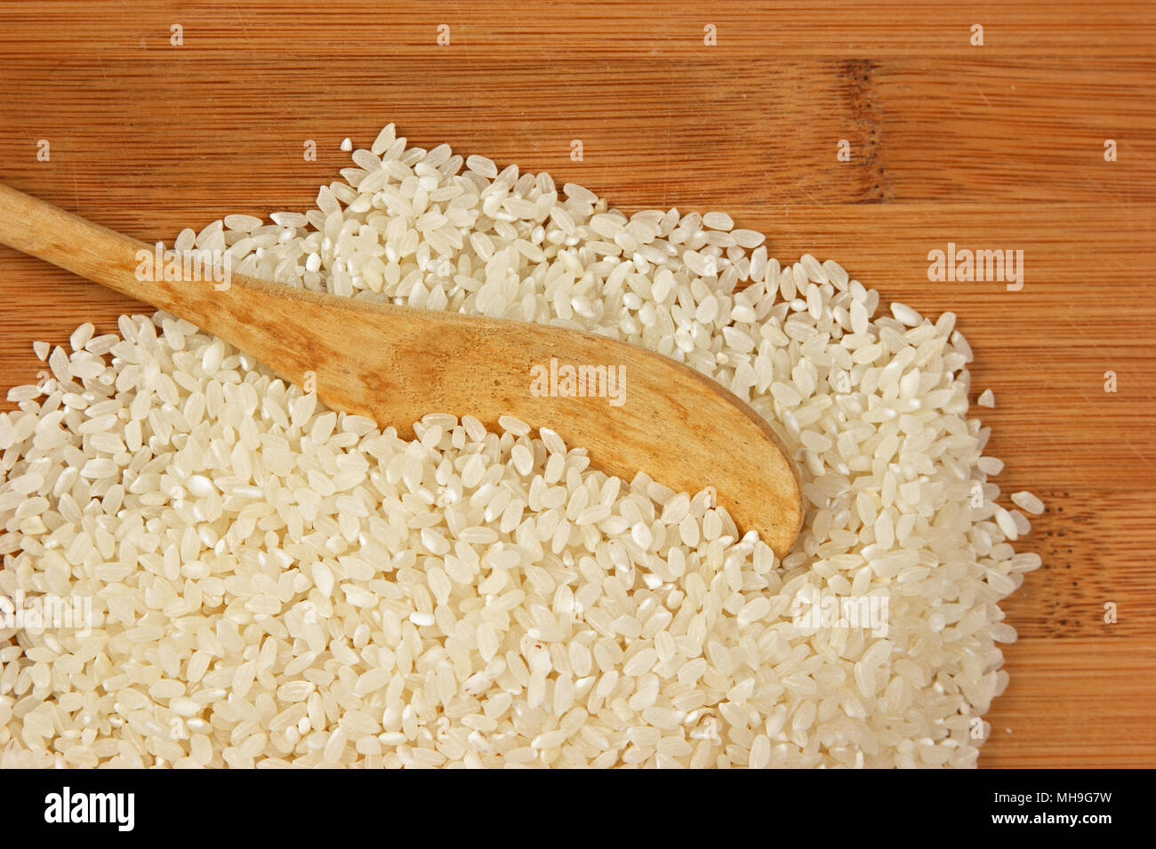 raw rice and wooden spoon on bamboo board Stock Photo - Alamy