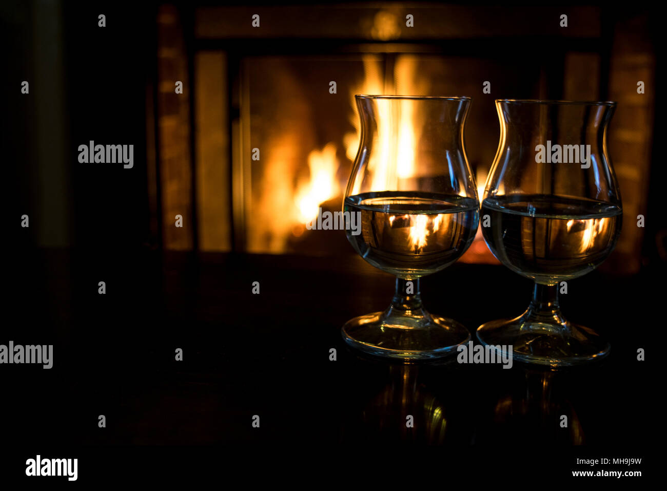 Two glasses of vodka by a roaring fire Stock Photo - Alamy