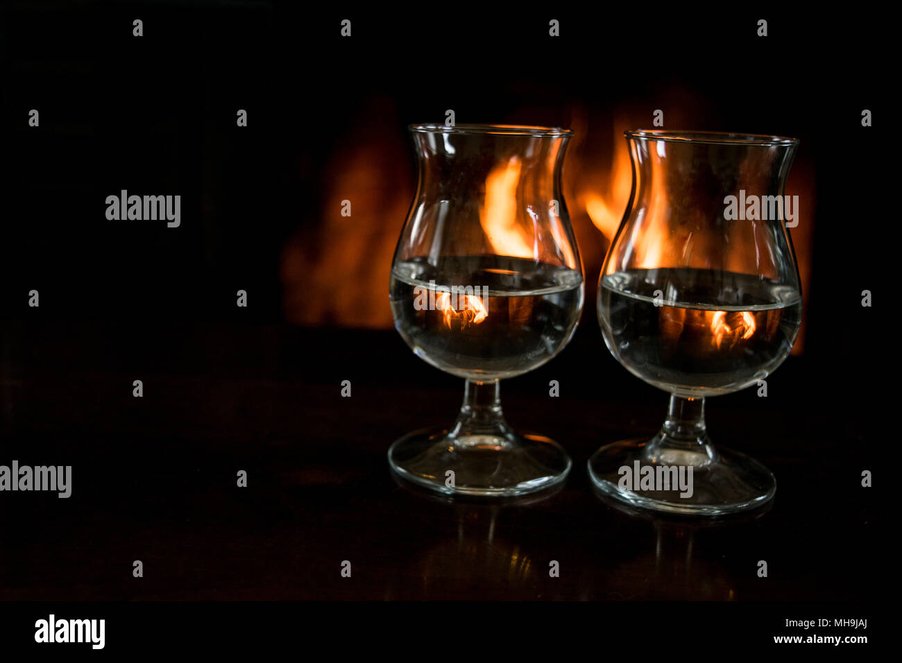 Two glasses of vodka by a roaring fire Stock Photo - Alamy