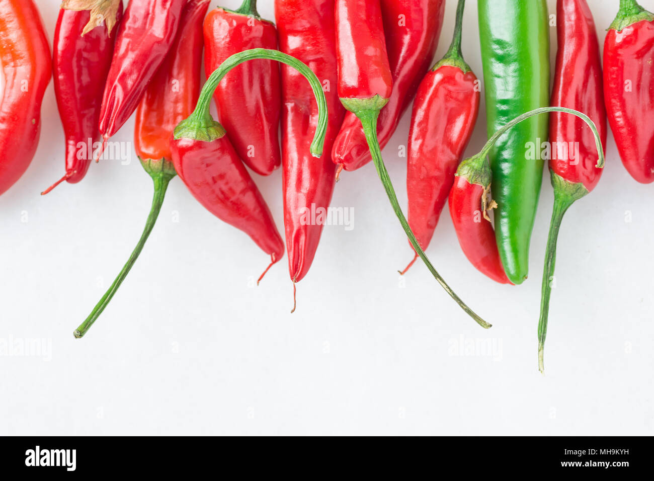 Row of Colorful Red and Green Hot Spicy Chili Peppers on White Marble ...