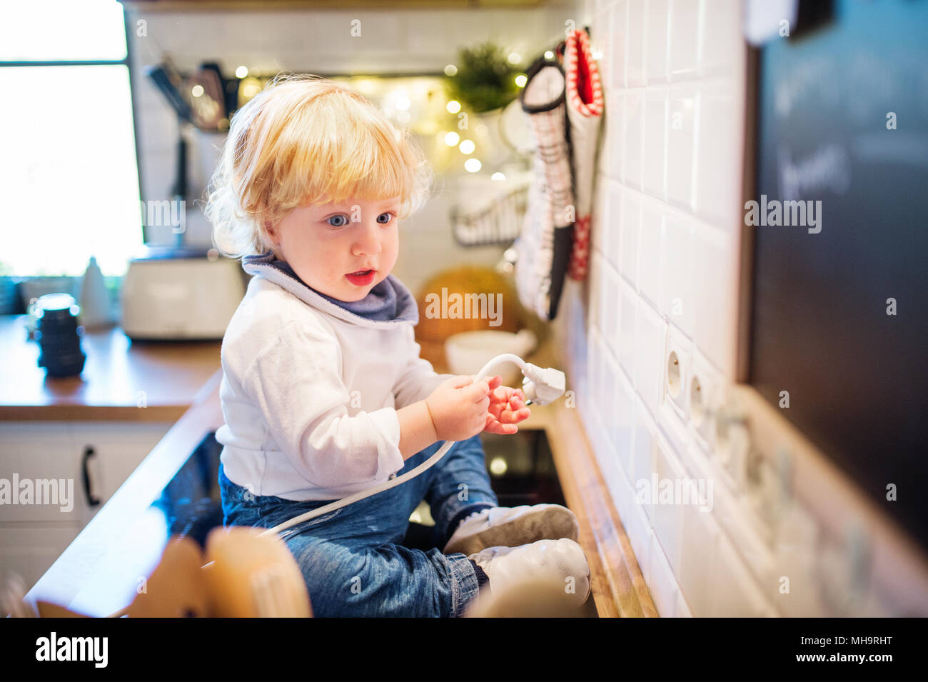 Toddler boy in dangerous situation at home. Child safety concept Stock ...